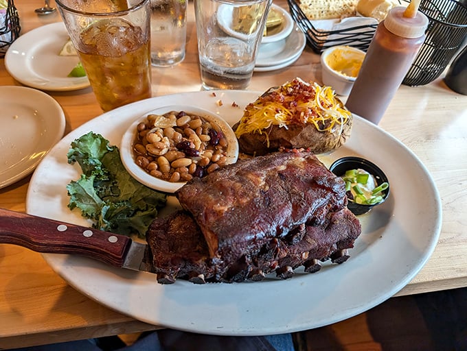 BBQ ribs with all the fixings—proof that happiness can indeed be served on a plate. That loaded baked potato is showing off, and we're here for it.