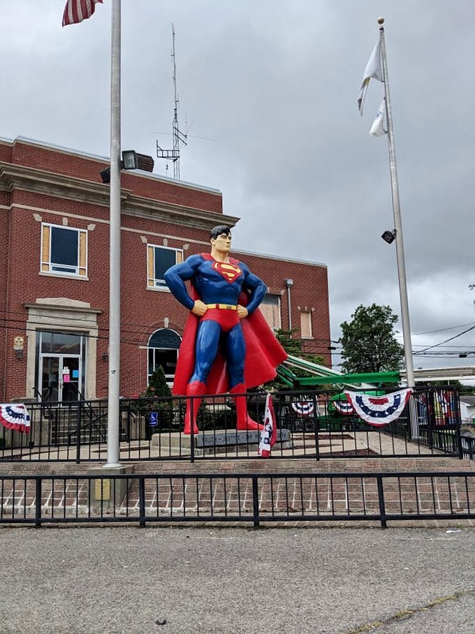 Three flags and one superhero—the ultimate symbols of American optimism standing guard outside the Massac County Courthouse.