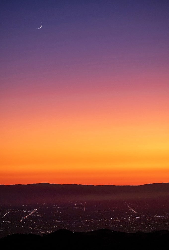 Nature's own light show outshines any Vegas spectacle. This sunset gradient from purple to orange makes even the most jaded traveler pause in wonder.