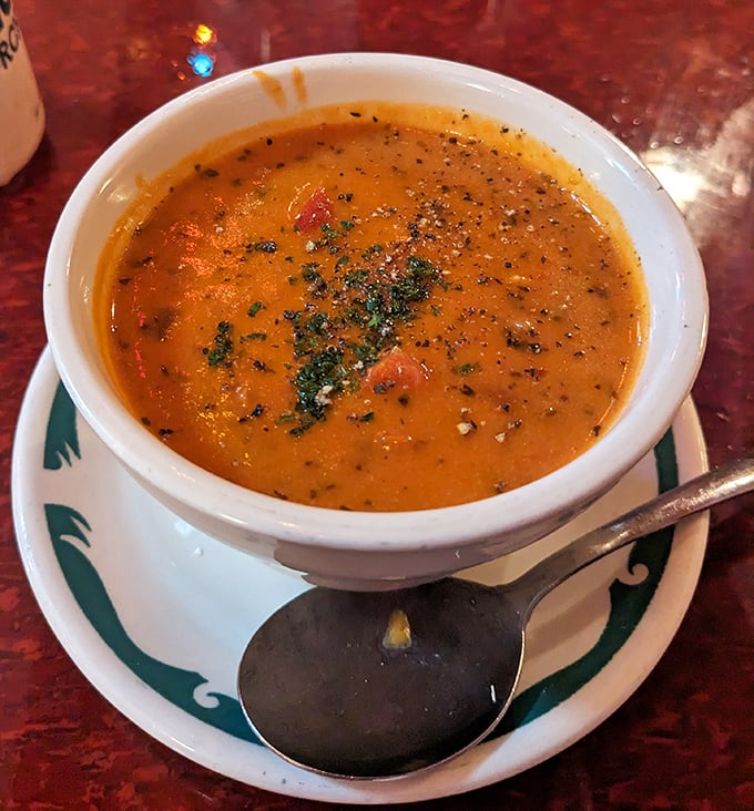 This isn't just soup—it's liquid comfort in a bowl, with herbs floating like tiny flavor rafts in a sea of tomato goodness.