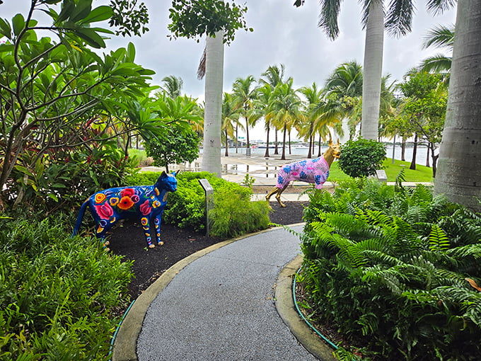 Two colorful canines stand guard along the winding path. The blue and multi-colored sculptures pop against Miami's lush tropical landscaping.