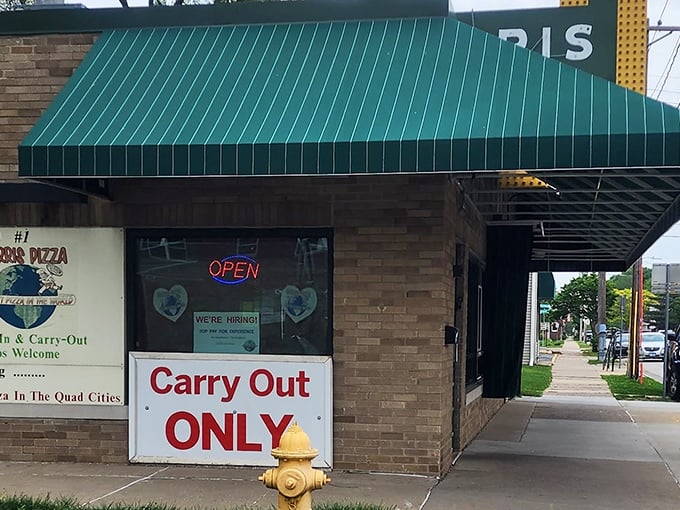 Harris Pizza's green awning stands like a beacon of Quad Cities pride – where scissors meet pizza destiny.