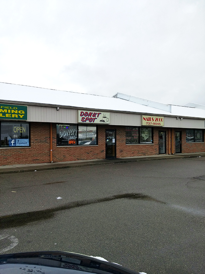 Strip mall locations often hide the greatest culinary gems - this colorful sign marks genuine donut treasure.