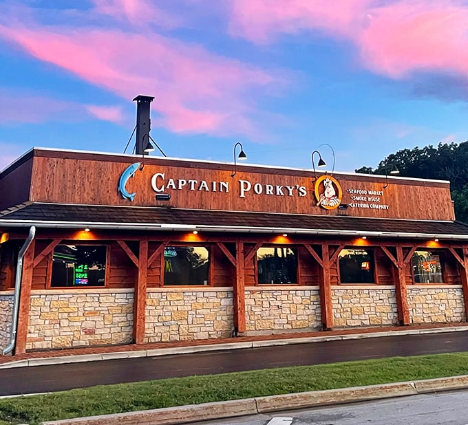 As twilight falls, Captain Porky's wooden facade glows with promise – seafood dreams in a log cabin setting.