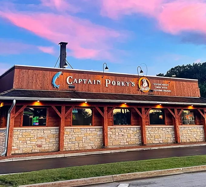 As twilight falls, Captain Porky's wooden facade glows with promise – seafood dreams in a log cabin setting.
