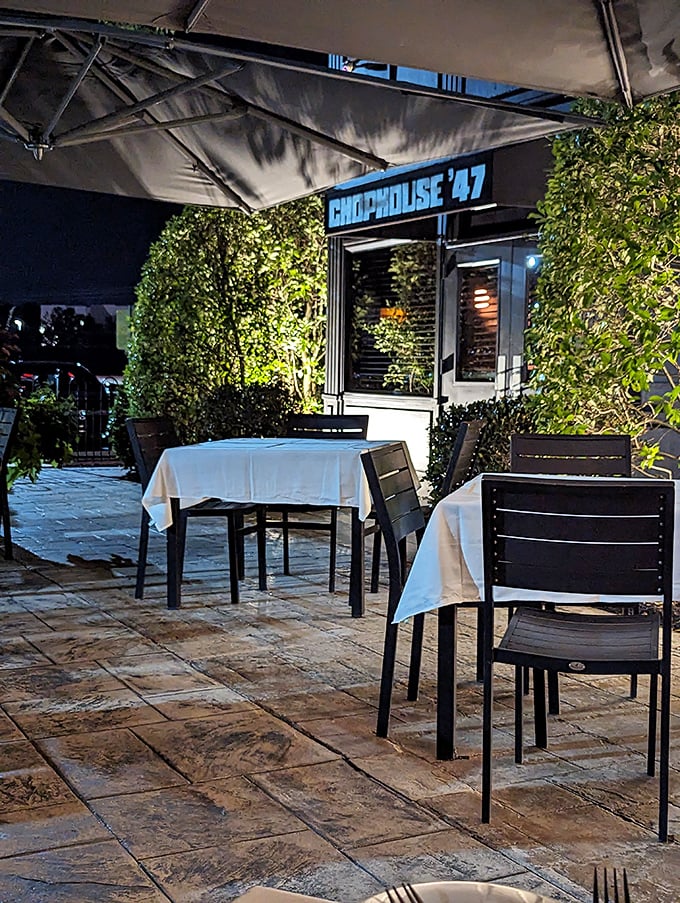 Evening ambiance transforms this steakhouse into something magical, where white tablecloths meet perfect atmosphere.