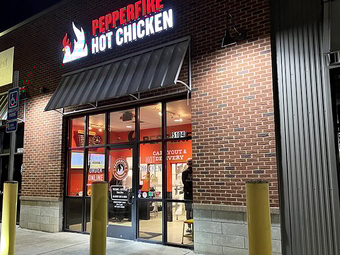 The Pepperfire storefront glows like a spicy beacon in the night. Those yellow safety poles aren't just for cars—they're to hold you up after the heat hits!