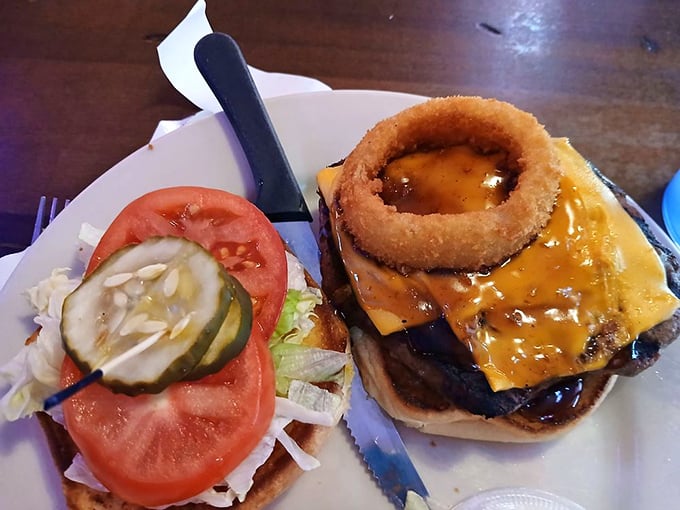 This burger defies gravity with its towering construction—complete with an onion ring crown that makes ordinary cheeseburgers look like commoners.