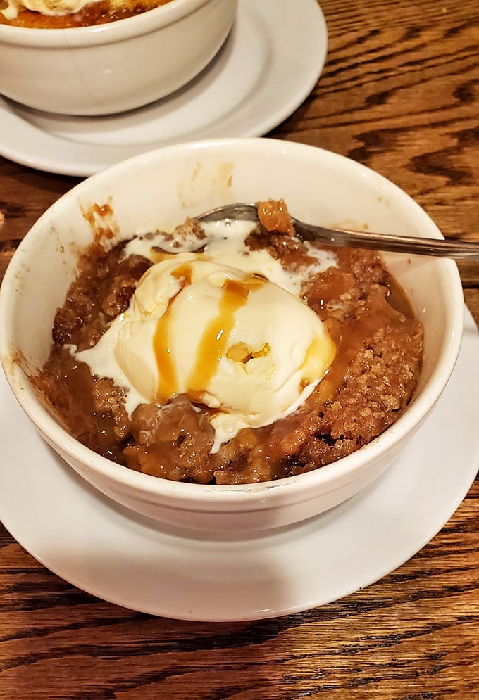 Dessert that understands its role: warm apple crisp topped with vanilla ice cream creating that magical hot-cold romance in every spoonful.
