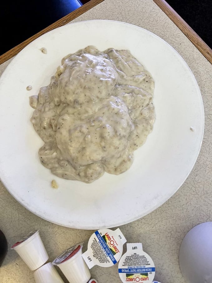 Biscuits and gravy that doesn't so much sit on the plate as command it—a creamy, peppery masterpiece that demands your full attention.
