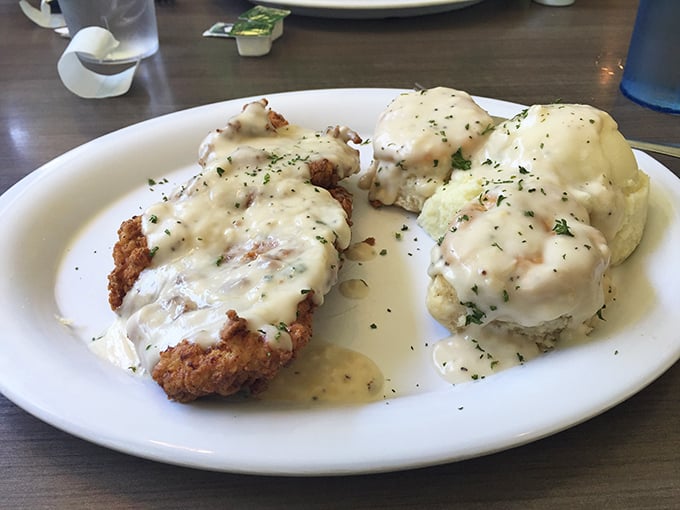 Country-fried steak smothered in creamy gravy alongside fluffy biscuits—a plate that says "you won't need dinner" in the most delicious way possible.