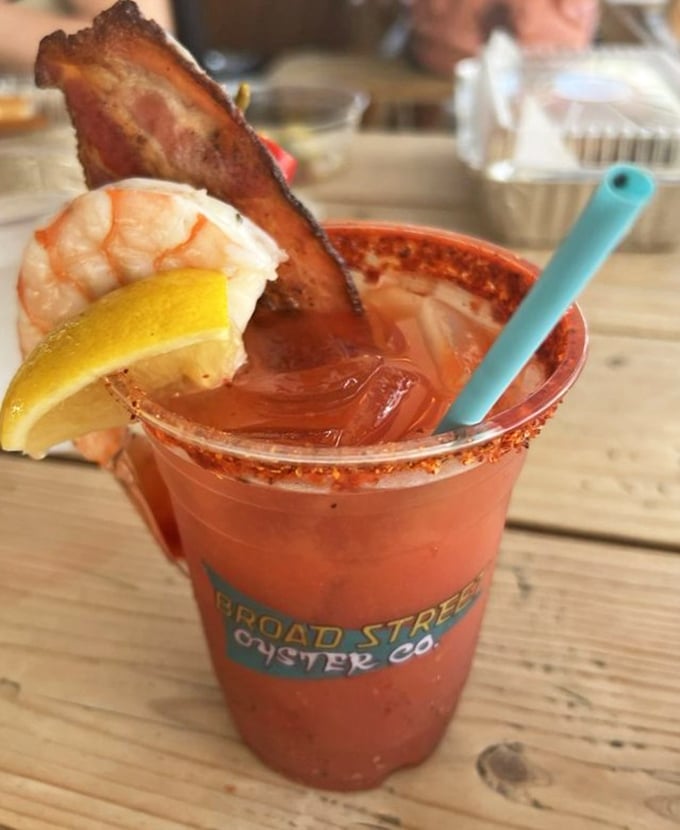 Their Bloody Mary comes armed for battle with a prawn perched on the rim and a bacon spear standing guard—breakfast, cocktail, and appetizer in one glorious glass.