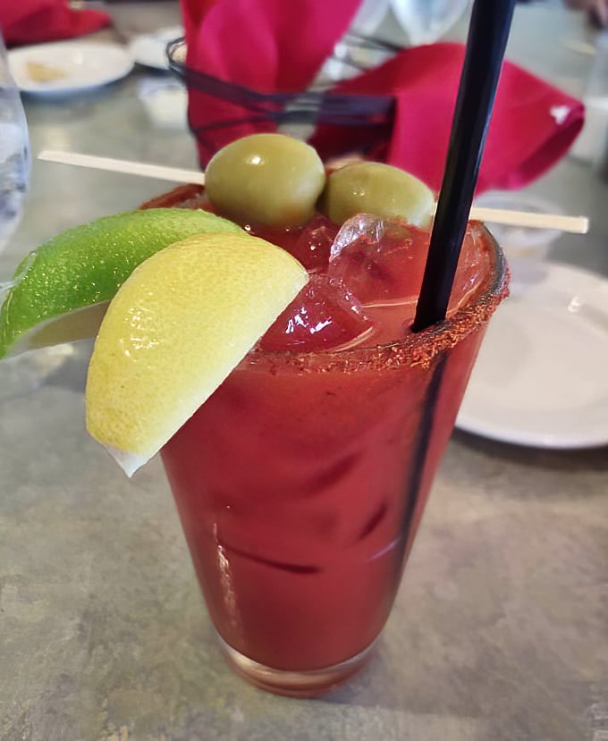A Bloody Mary that's practically a meal unto itself. Those olives aren't garnish—they're lifeguards watching over a sea of spicy tomato goodness.