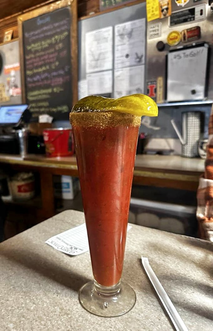 A Bloody Mary tall enough to have its own ZIP code. That pickle spear isn't a garnish—it's a diving board into a pool of savory morning redemption.