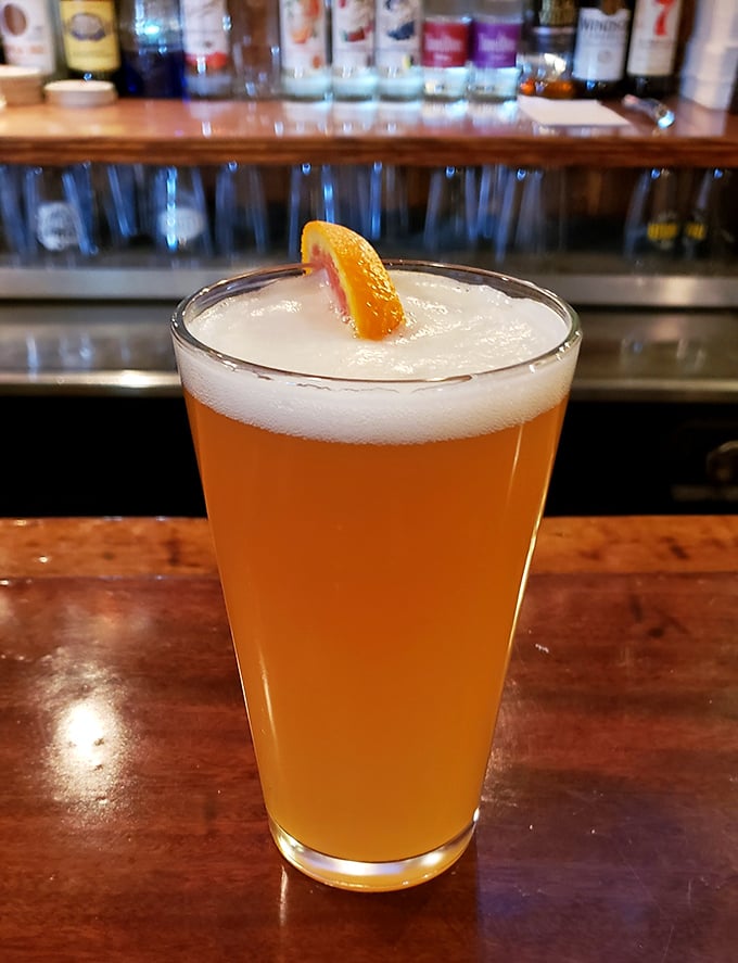 A cold craft beer with that perfect orange slice garnish – the ideal companion while deciding between stromboli and pizza (correct answer: both).