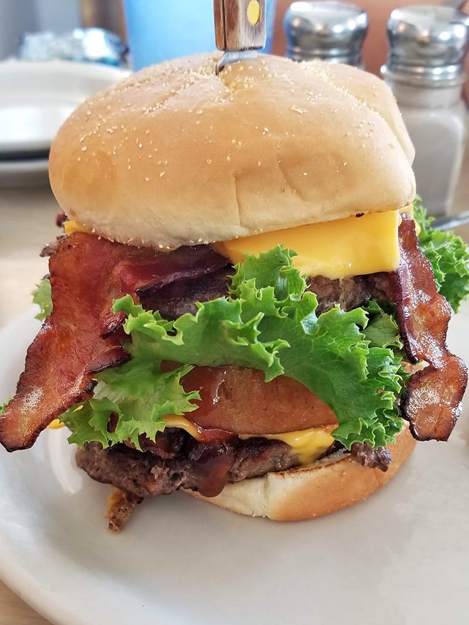 A burger that requires jaw exercises before attempting. Those bacon strips aren't ingredients—they're statements of purpose.