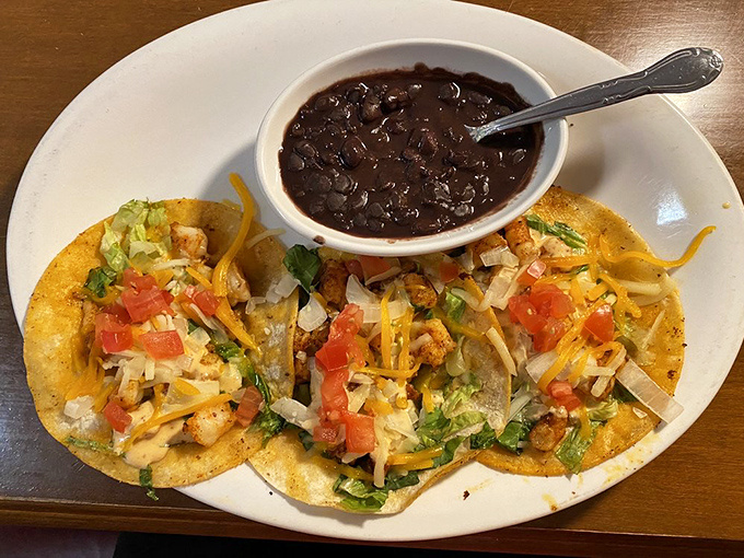 Tacos that demand to be photographed before eaten. Fresh toppings, melted cheese, and black beans that aren't just a side—they're an essential character in this story.
