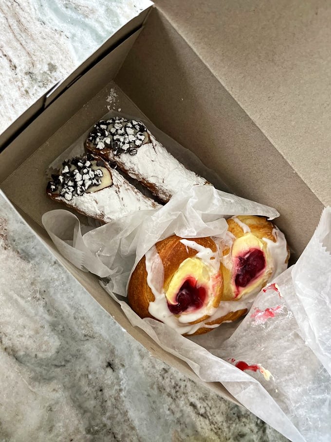 Cannoli and cherry Danish sharing a box like the odd couple of pastries—one traditional, one fruit-forward, both irresistible.