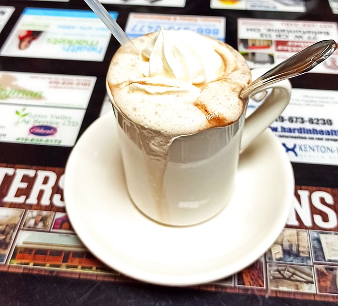 A cappuccino topped with whipped cream and caramel drizzle. Coffee elevated from morning necessity to midday indulgence.