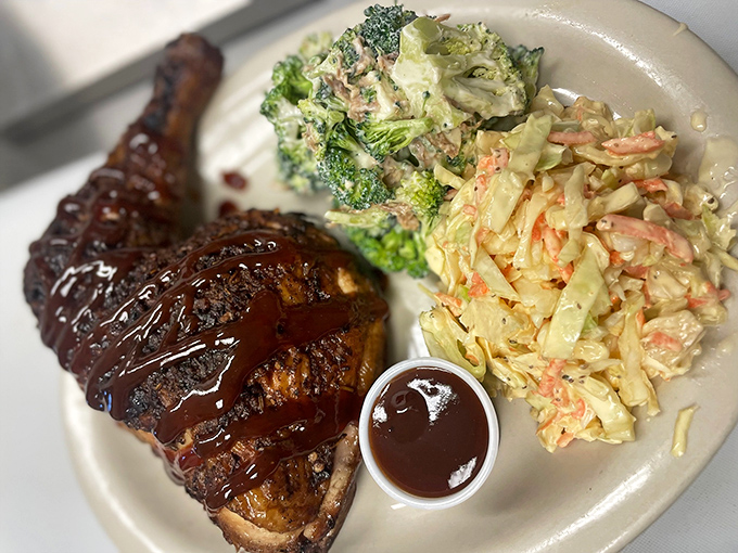 Chicken that proves barbecue isn't just a red meat game – glistening with sauce and flanked by sides that refuse to be afterthoughts.
