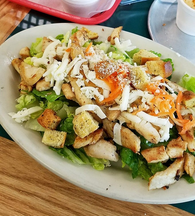 A chicken Caesar salad that doesn't apologize for being exactly what it should be – fresh, generous, and proof that not everything delicious requires melted cheese.