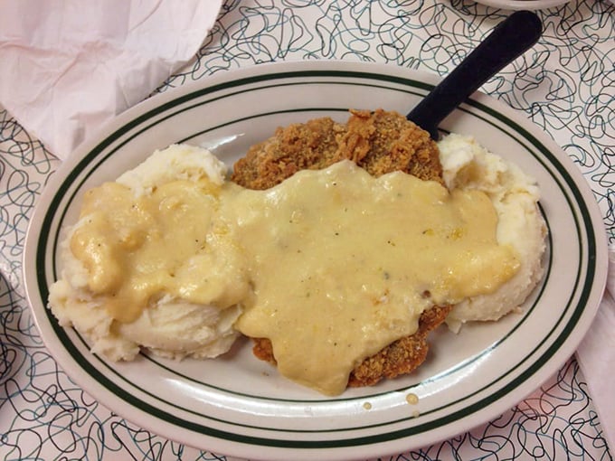 Chicken fried steak smothered in country gravy alongside golden mashed potatoes – the kind of plate that makes cardiologists wince and taste buds rejoice.