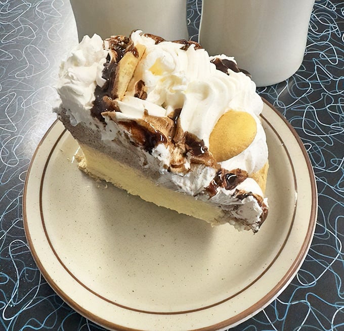 Not all heroes wear capes—some wear whipped cream, bananas, and chocolate drizzle atop a throne of custard filling.