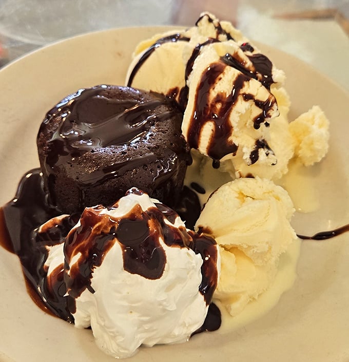 This chocolate lava cake doesn't just ooze—it performs a volcanic eruption of warm fudge that makes ice cream surrender immediately to its warm embrace.