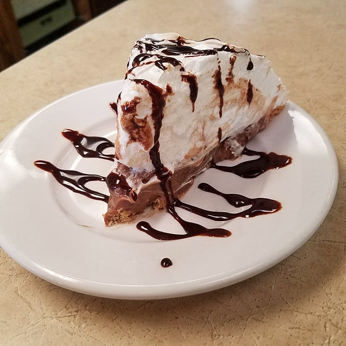 Chocolate cream pie with a mountain of meringue and chocolate drizzle—proof that happiness can indeed be served on a plate.