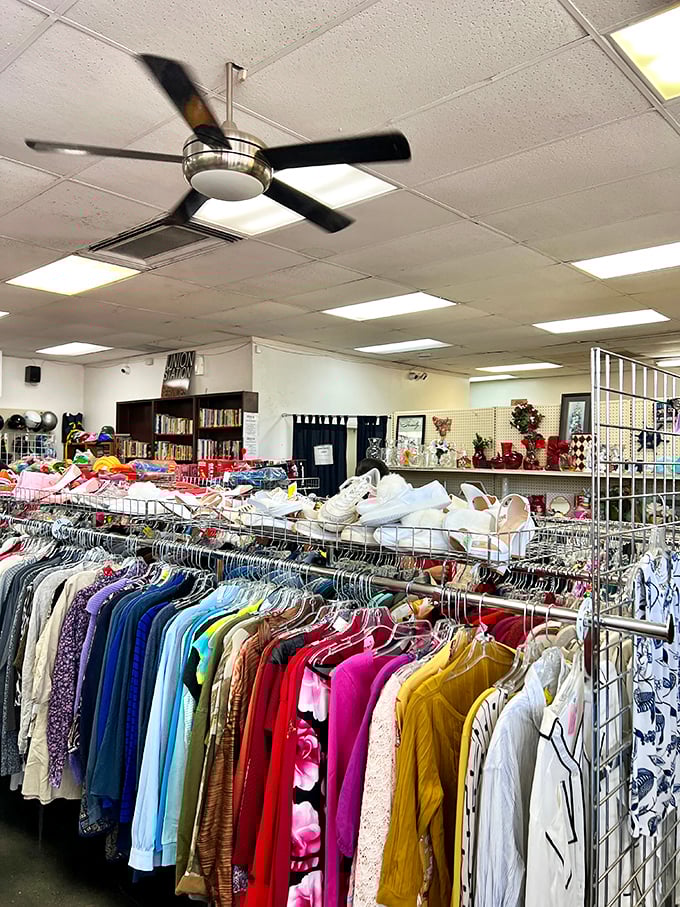 Ceiling fans circulate possibilities while shoppers browse through meticulously organized clothing racks sorted by type rather than brand.