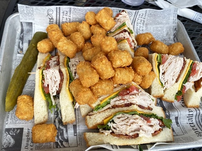 The club sandwich and tater tots combo – proof that sometimes the classics endure because they're simply unbeatable, especially on newspaper-lined baskets.