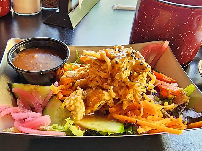 This isn't just a salad—it's a crunchy, colorful celebration topped with what appears to be crispy chicken and served with a side of satisfaction.