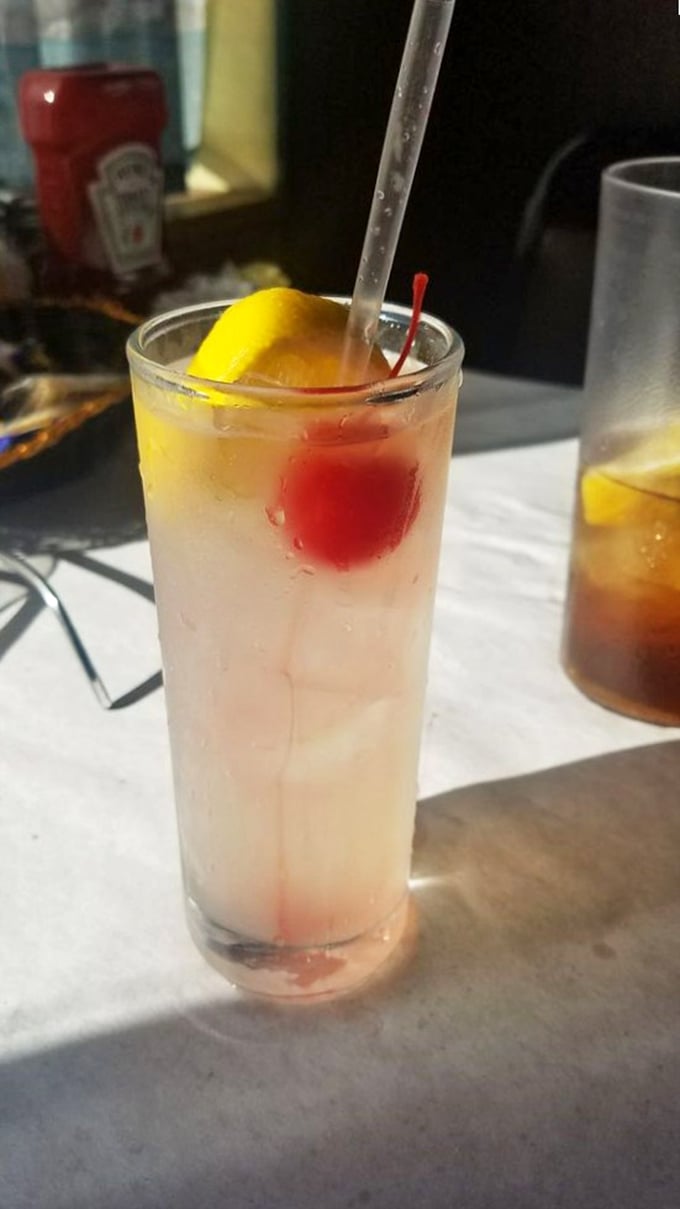 A Tom Collins with that cherry and lemon slice isn't just a drink—it's the perfect intermission between seafood acts.