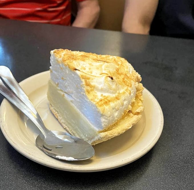 This slice of coconut cream pie isn't just dessert—it's a fluffy cloud of sweetness that makes you question why you ever considered saving room.