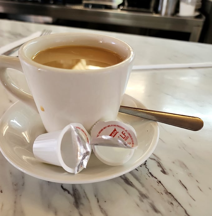 Coffee served with those little creamer cups—proof that sometimes the simplest pleasures are the most satisfying.