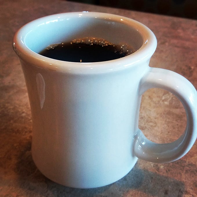 The lifeblood of morning warriors everywhere—honest-to-goodness diner coffee in a sturdy mug that promises unlimited refills and unlimited possibilities.