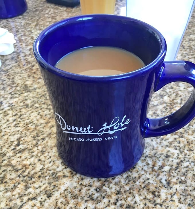 The iconic blue mug—holding liquid motivation that keeps coming until you've solved all the world's problems over breakfast. 
