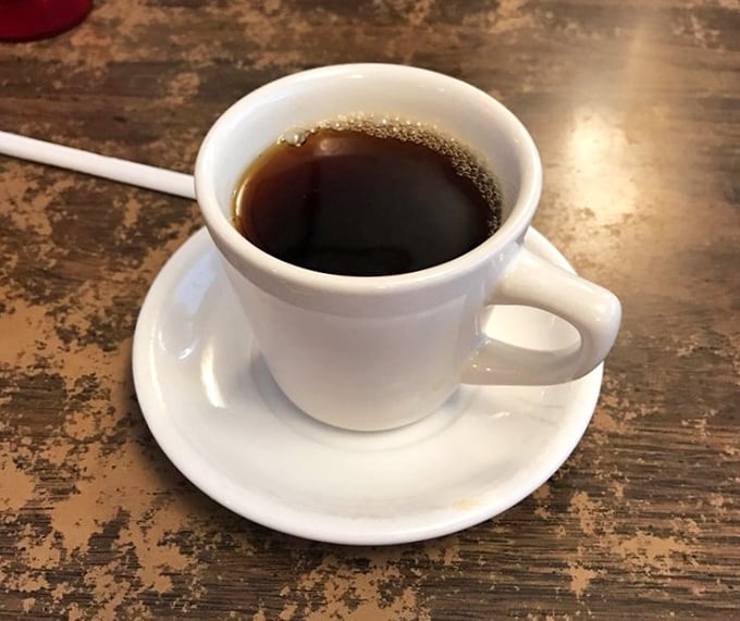The humble white mug contains diner coffee in its purest form—strong enough to resurrect the dead but served with enough refills to make you feel truly alive.