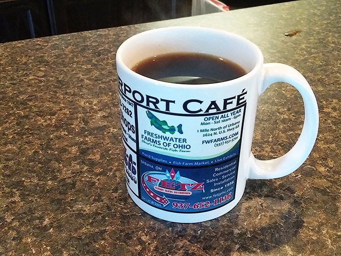 The official fuel of morning conversations, served in a mug that tells stories of local pride and the cafe's place in Urbana's heart.