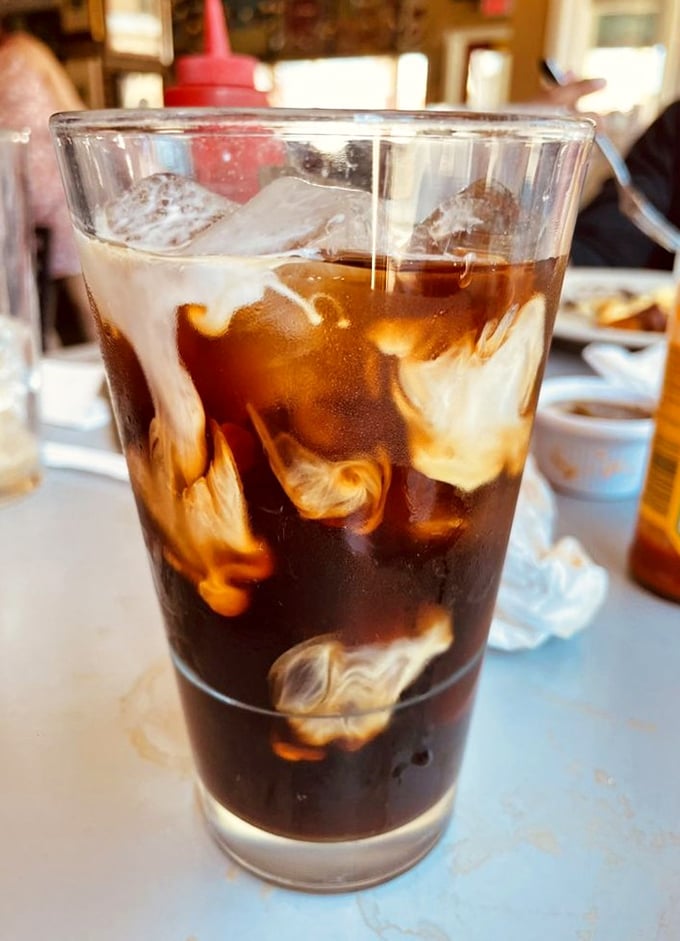 The cafe's cold brew with cream swirls like a caffeinated work of art—the perfect companion for contemplating your next menu selection.