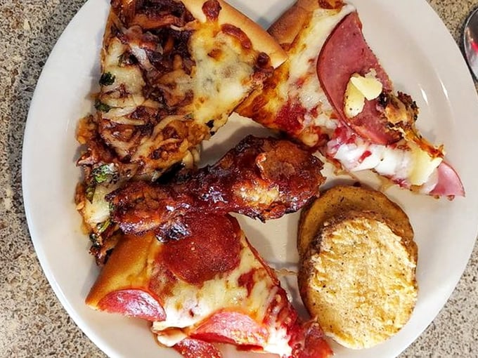 Pizza and chicken on one plate? This isn't indecision—it's brilliant buffet strategy. The golden garlic bread is the supporting actor stealing the scene.