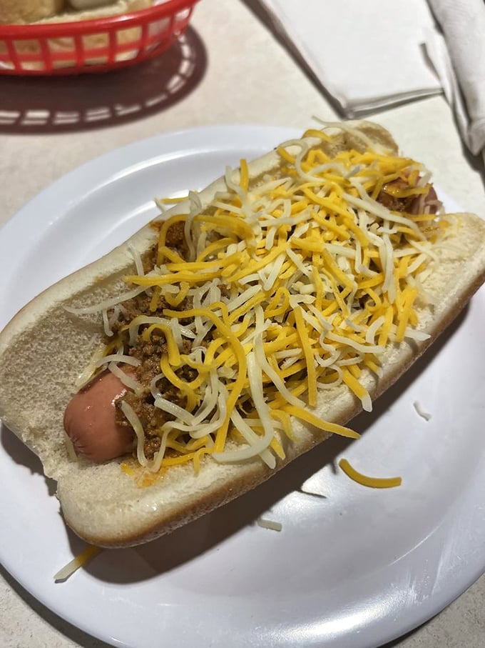 The classic Coney dog, blanketed in meat sauce and crowned with shredded cheese – a handheld masterpiece that's been perfecting its recipe since your parents' first date.