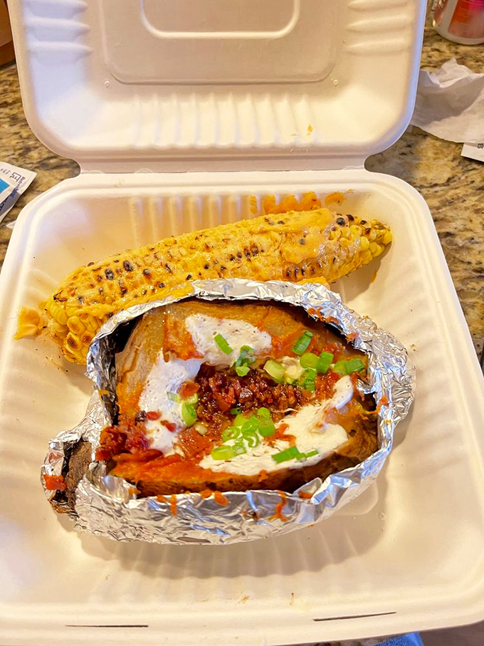 Corn on the cob and a loaded potato—proof that in barbecue land, even the vegetables dress up for the occasion.