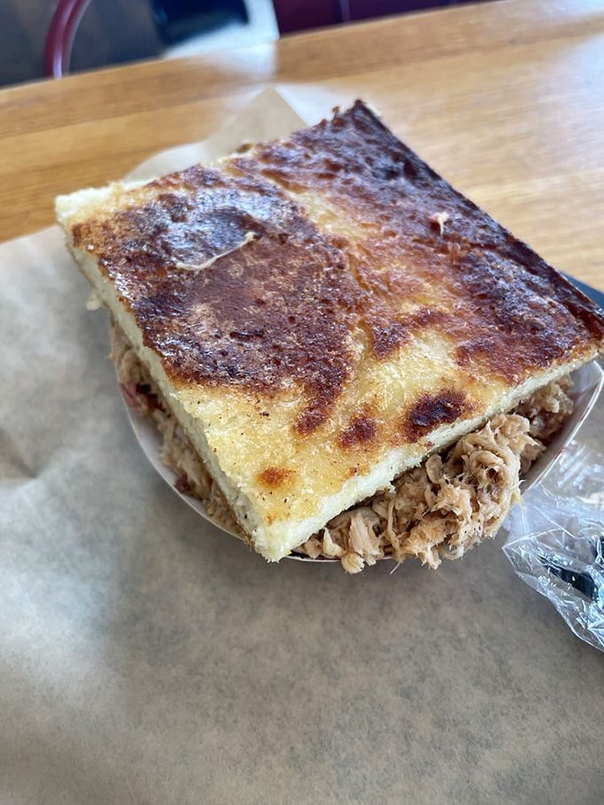 The cornbread here isn't the sweet, cakey Northern version—it's a savory, dense platform engineered specifically for barbecue transportation to your mouth.