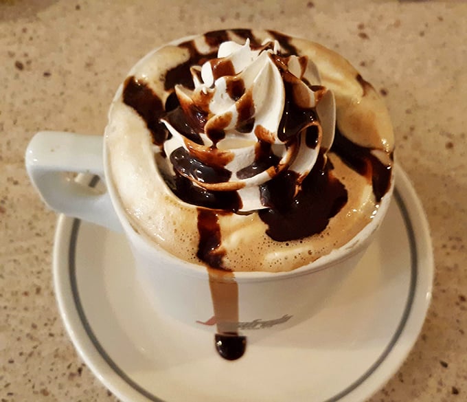Coffee art so pretty you almost don't want to drink it—almost. The chocolate drizzle is just showing off at this point.