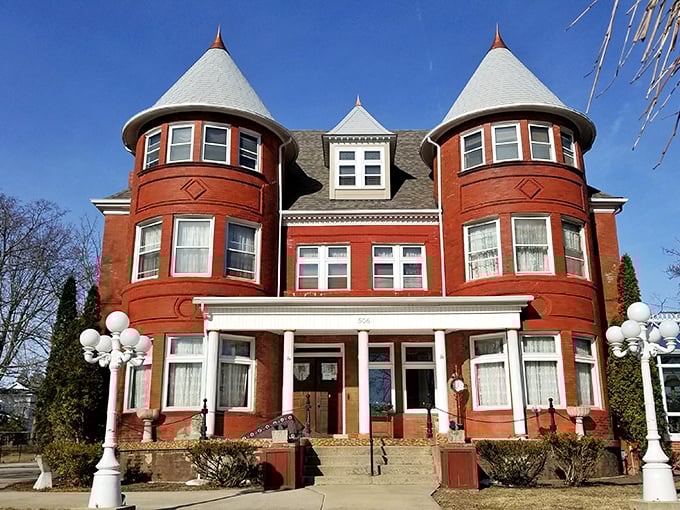 This brick mansion with twin turrets isn't compensating for anything – it's just showing off what lumber baron money could buy in 1890s Michigan.