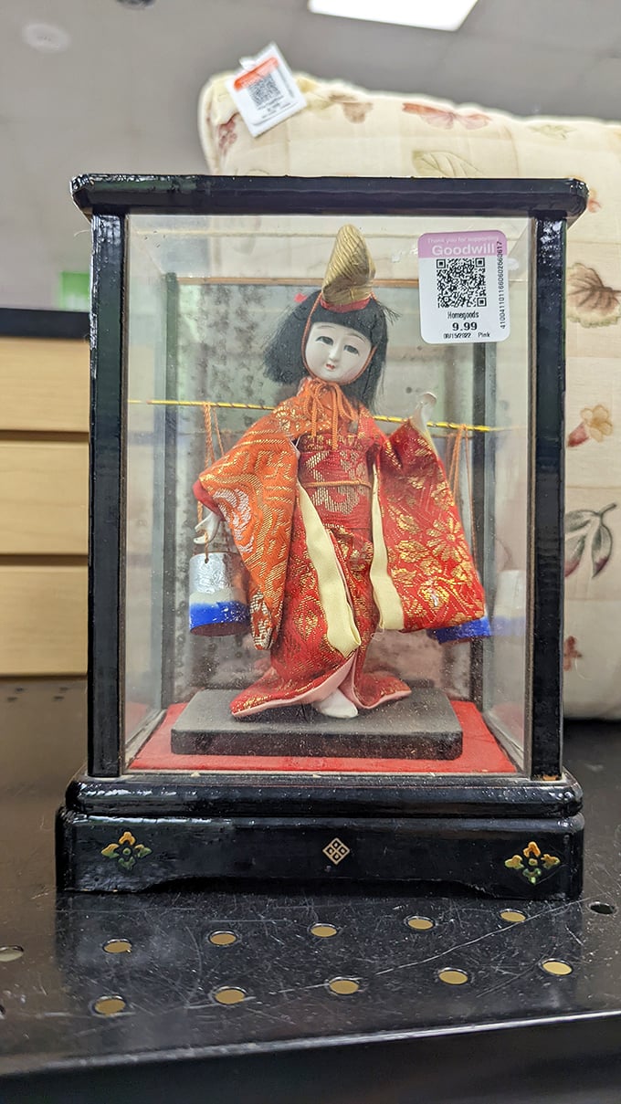 A delicate Japanese doll in traditional kimono attire – someone's cherished keepsake now awaiting its second chapter.