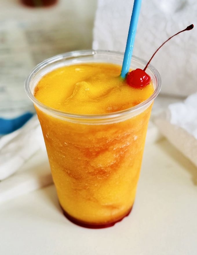 That golden-orange frozen concoction isn't just a drink—it's liquid sunshine with a cherry on top. Florida in a glass.