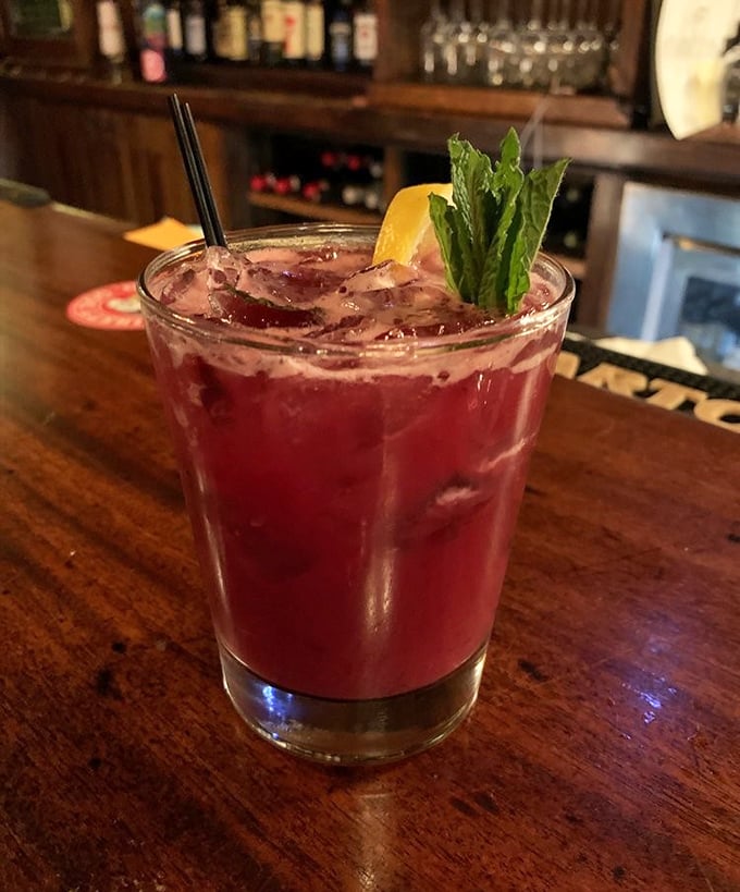 A ruby-red cocktail that's equal parts art and libation, garnished with fresh mint and promising good decisions or at least very enjoyable bad ones.