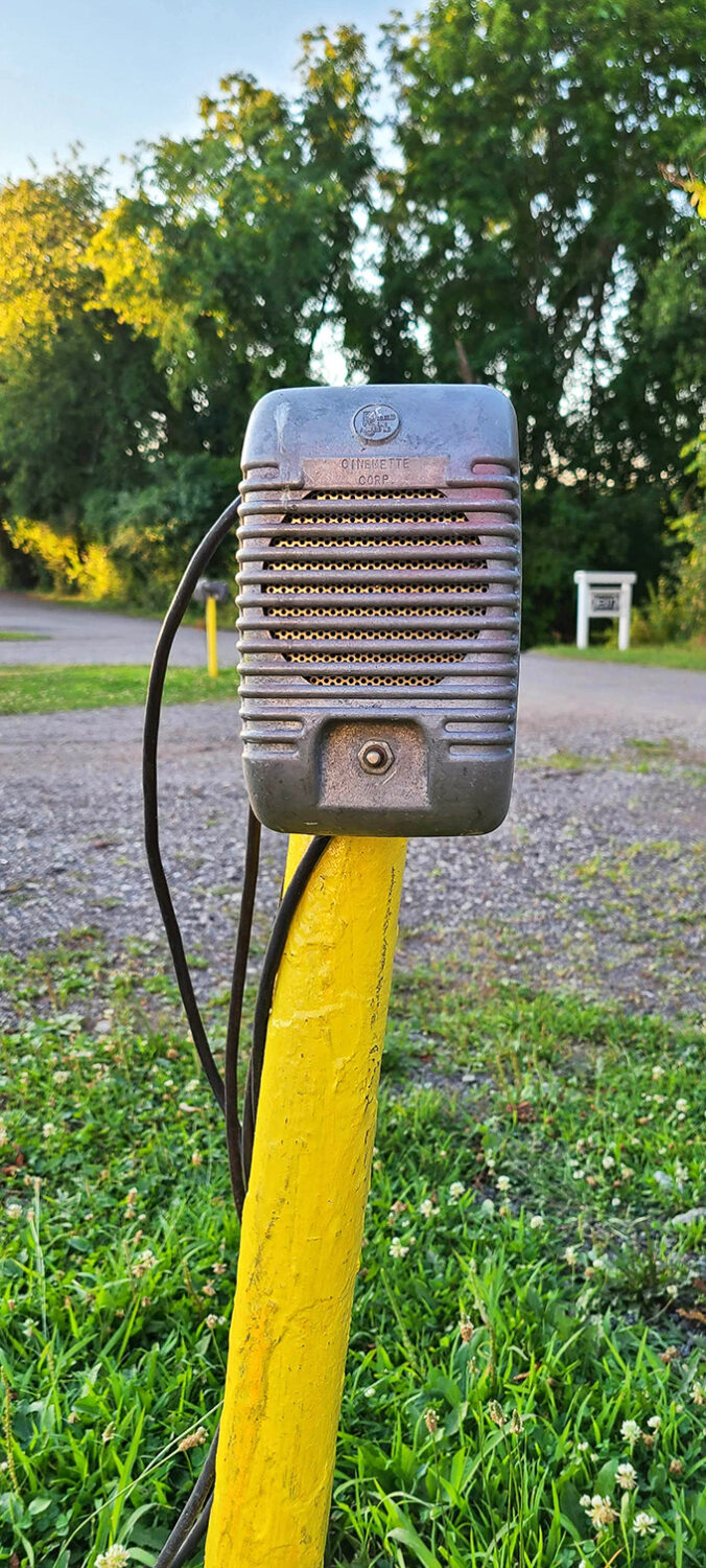A vintage Cinematone speaker—the original podcast device—still standing guard on its yellow post, ready to whisper movie magic.